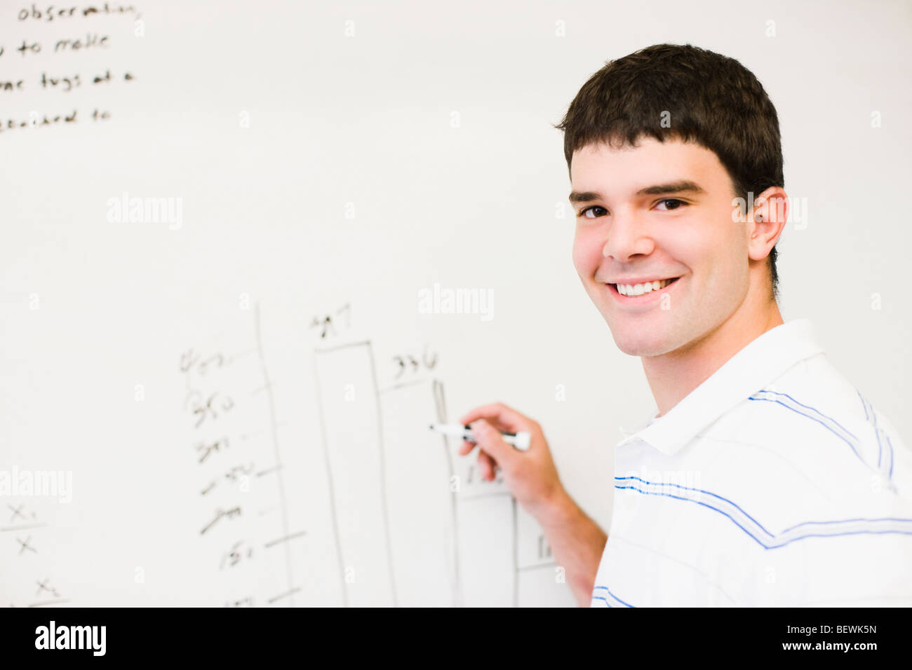 Student writing on a whiteboard Stock Photo - Alamy