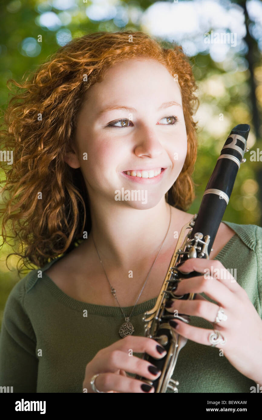 Woman holding a clarinet and smiling Stock Photo - Alamy