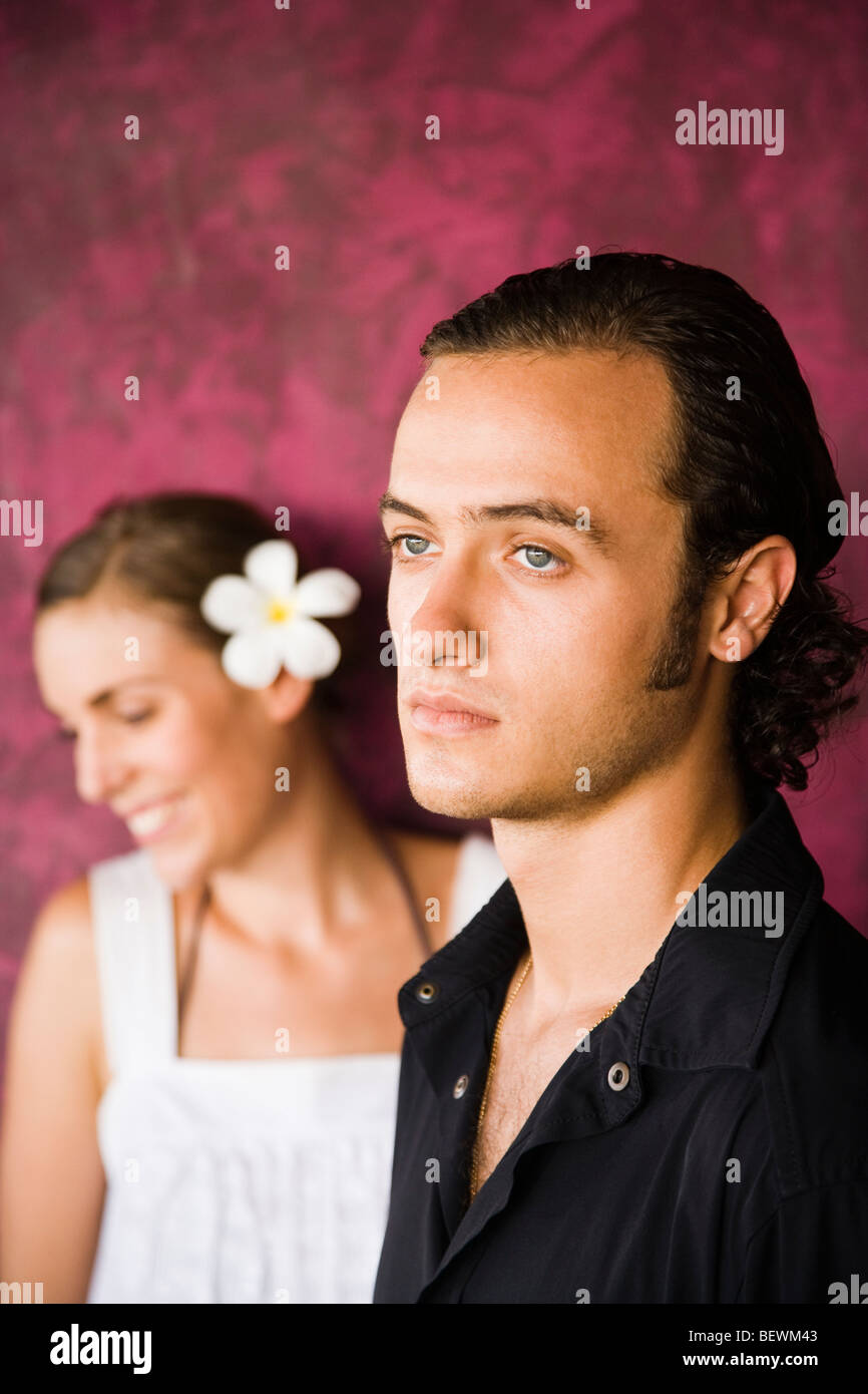 Man looking sad with a woman smiling in the background Stock Photo - Alamy