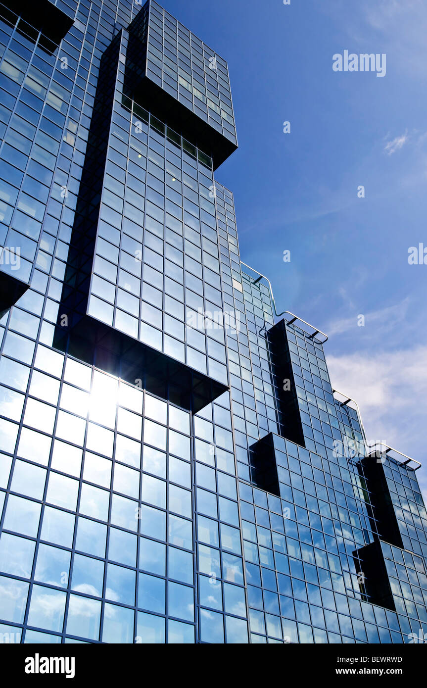 Modern geometric city building reflecting sun and clouds Stock Photo ...