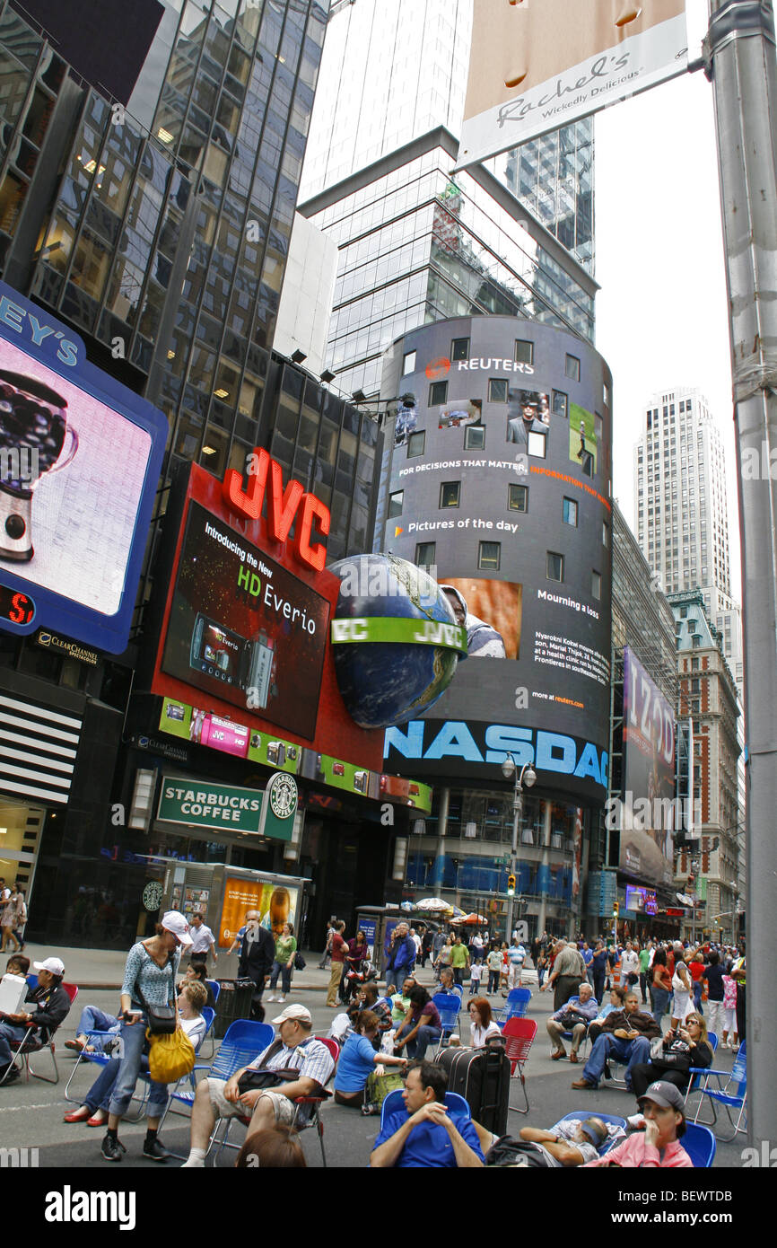 Neon signs and people resting on Times Square, New York city,USA Stock ...