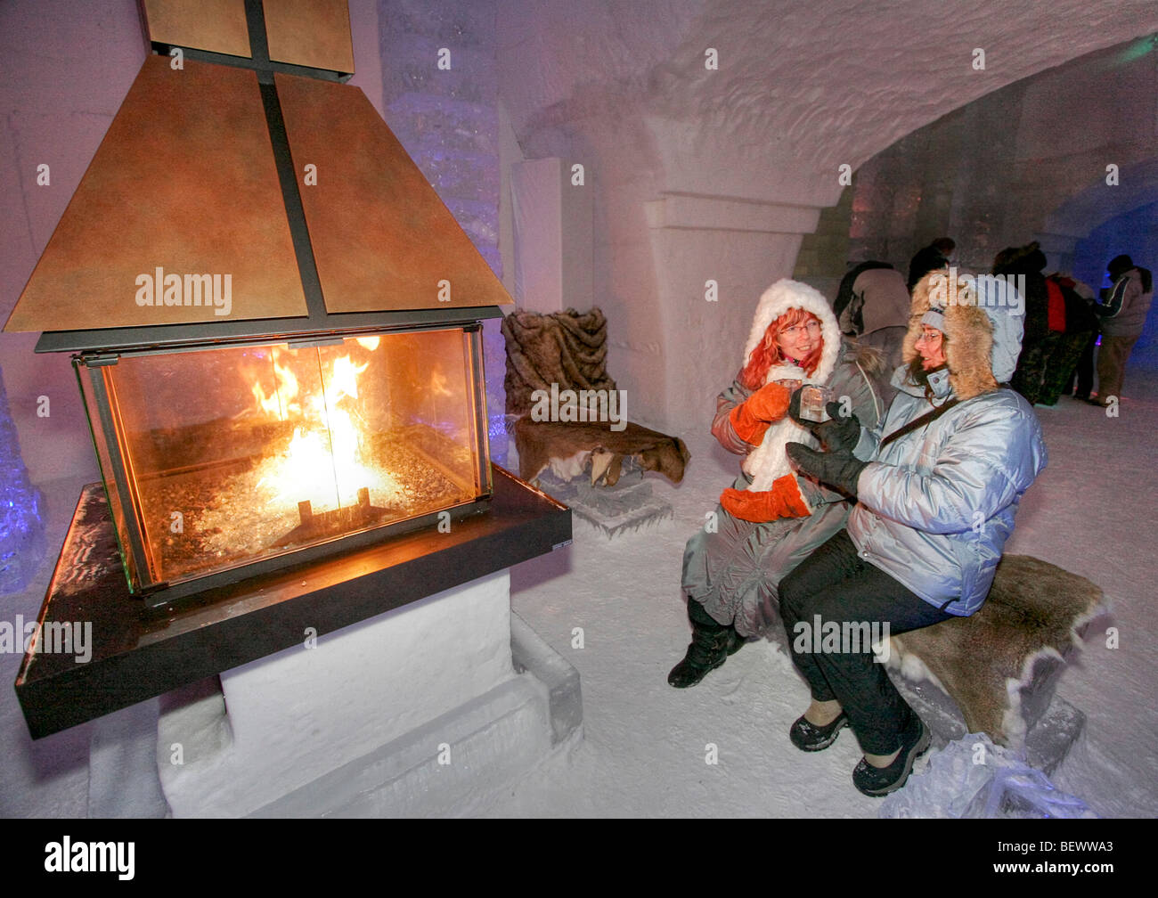 Two women sit by fire in N'Ice Club (lounge) of Ice Hotel at Duchesnay ...