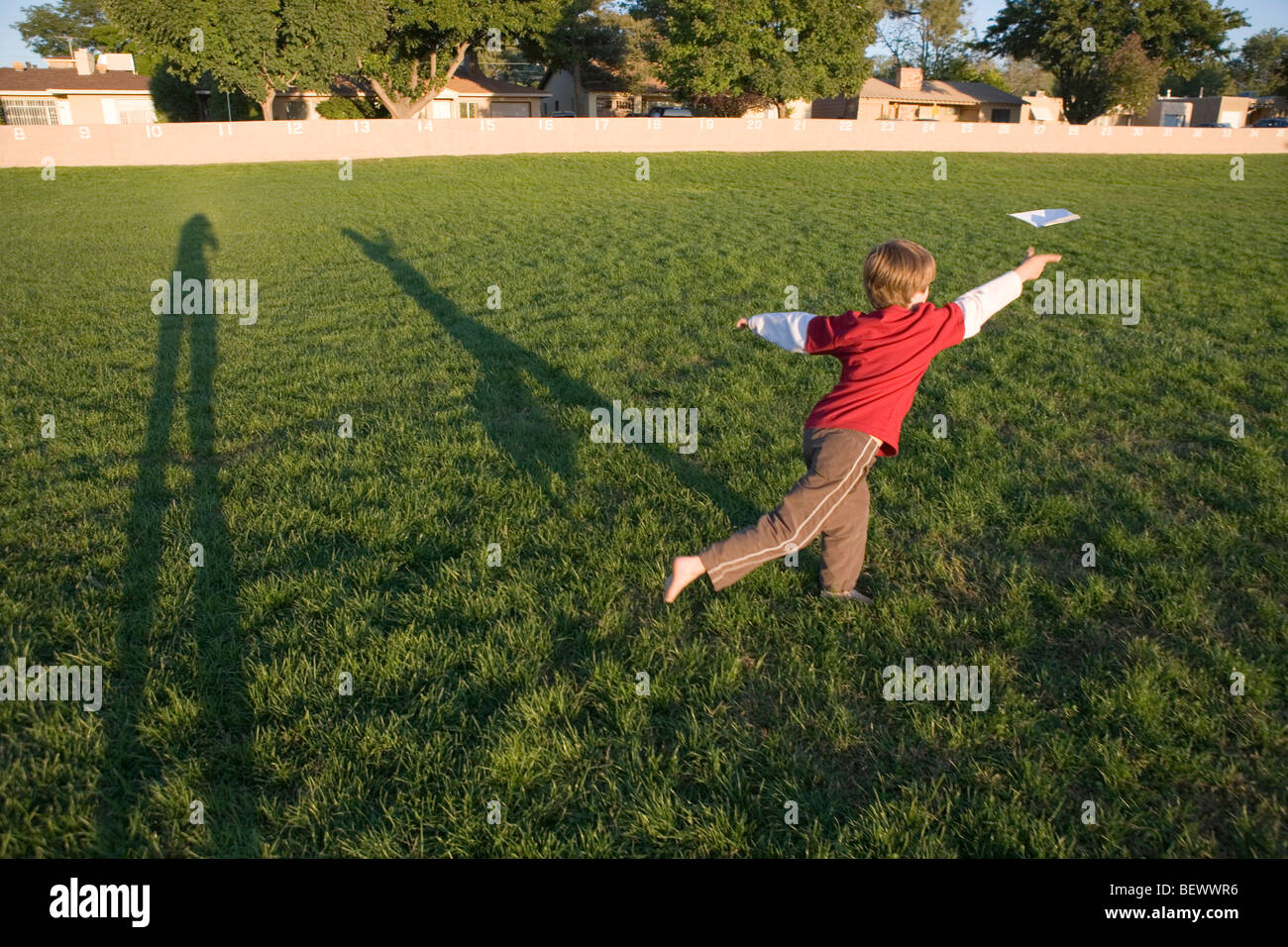 seven year old throwing a paper airplane at a park, dusk Stock Photo ...