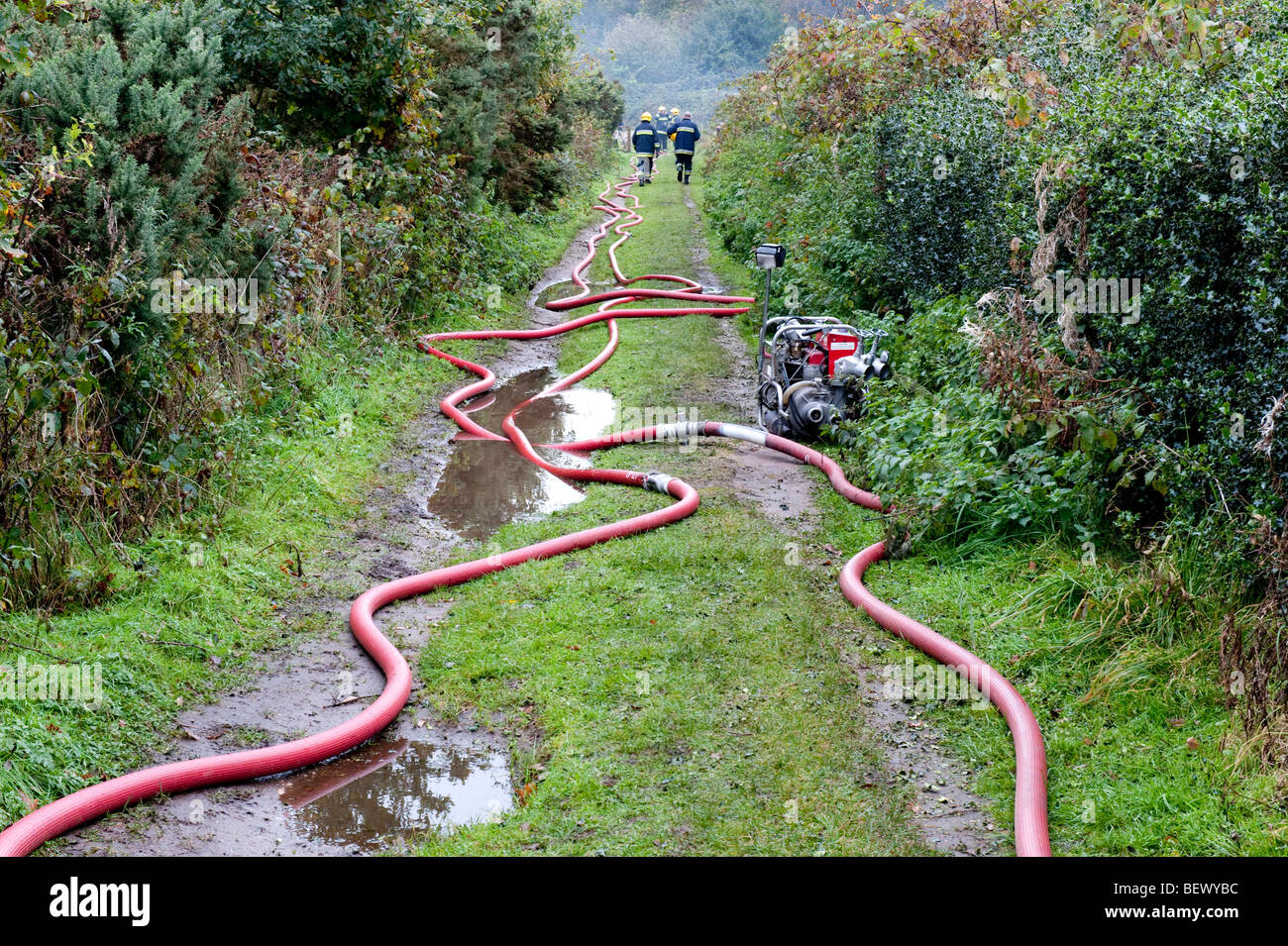 Fire hose in country lane to allow fire service to fight barn fire at ...