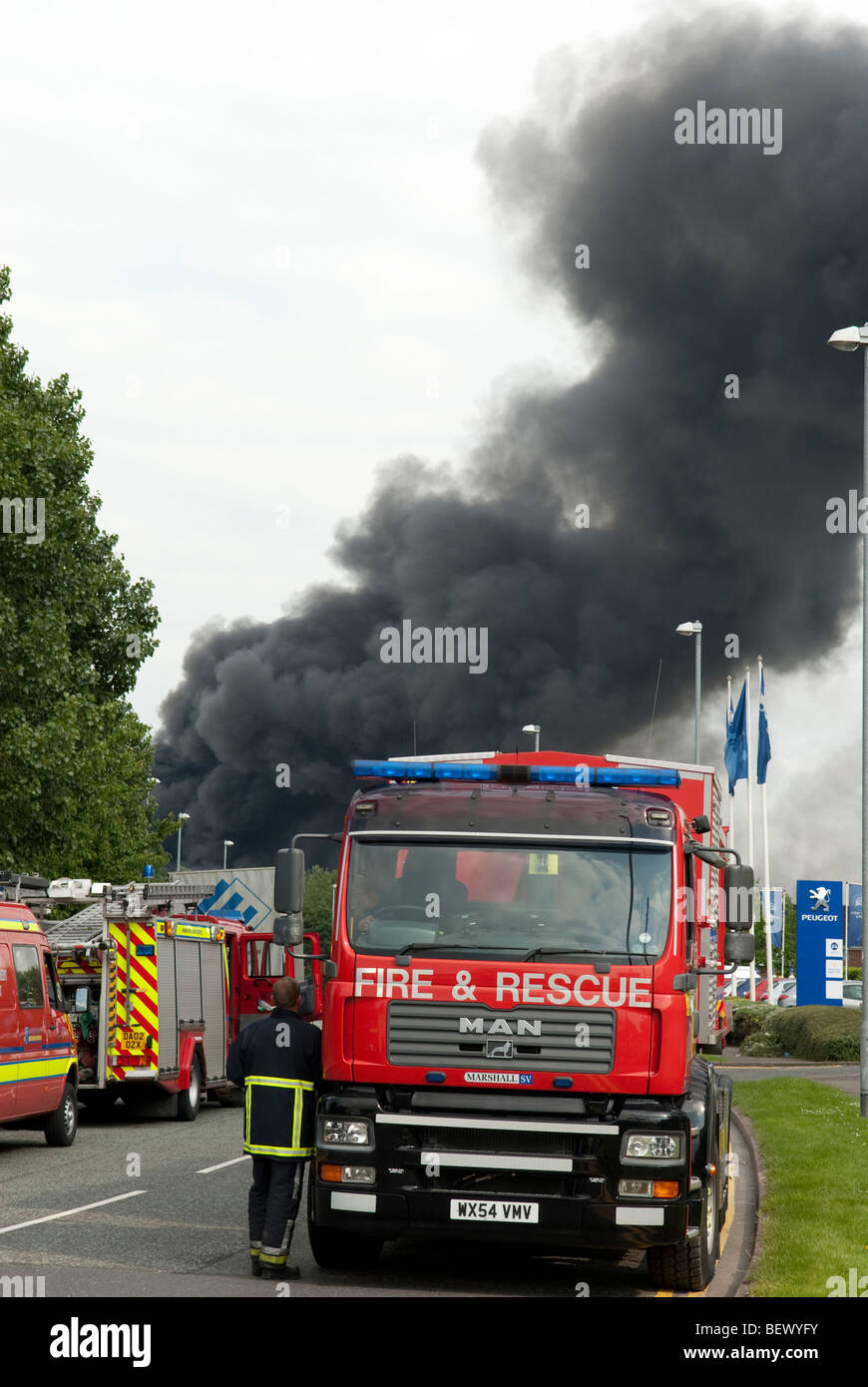 Fire engine with large plume of black smoke at factory fire Stock Photo ...