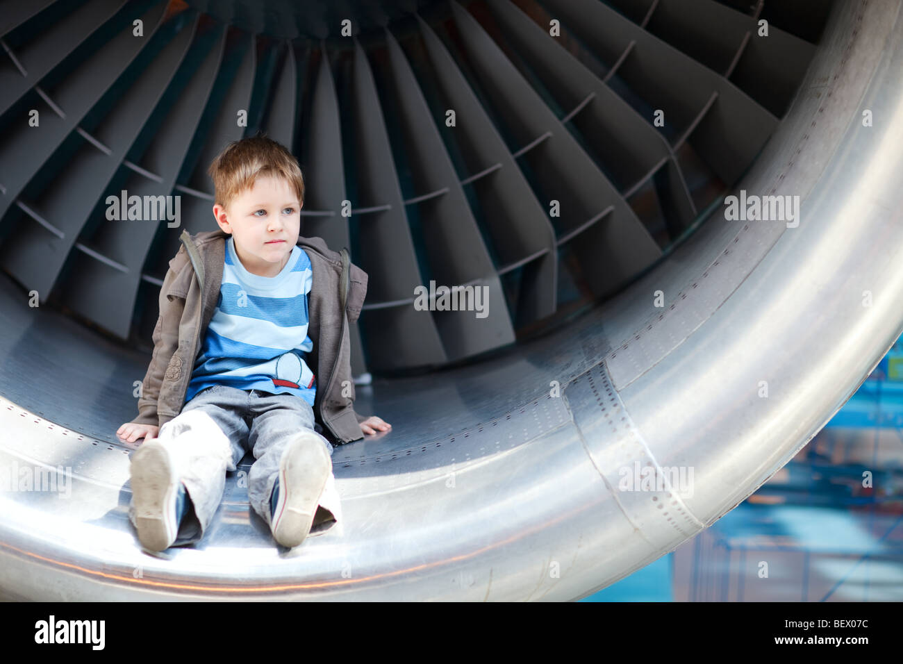 Boy sitting inside aircraft turbine Stock Photo - Alamy
