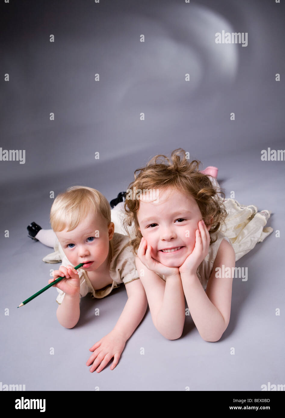 Studio photo of two sisters over gray background Stock Photo - Alamy