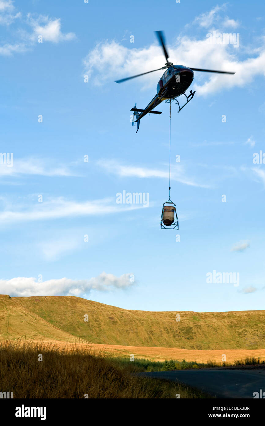 Small helicopter being used for working on hill repairs in the ...