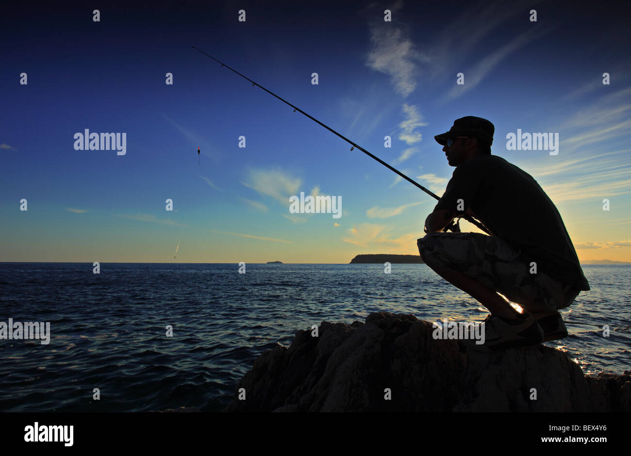 Man fishing on sunset Stock Photo - Alamy