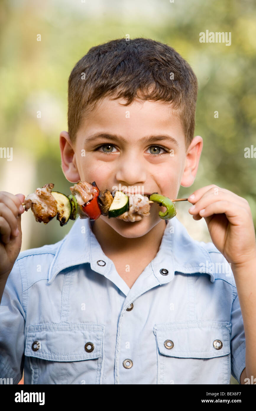 Boy eating a skewer Stock Photo - Alamy