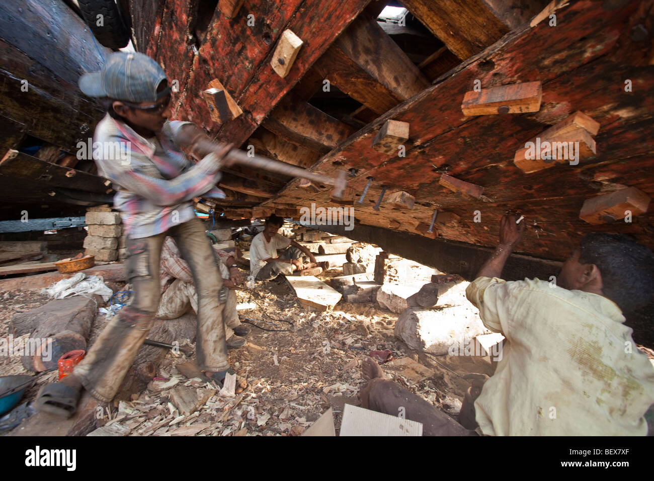 Gujarat ship builders repair a wooden fishing boat in the shipyards of ...