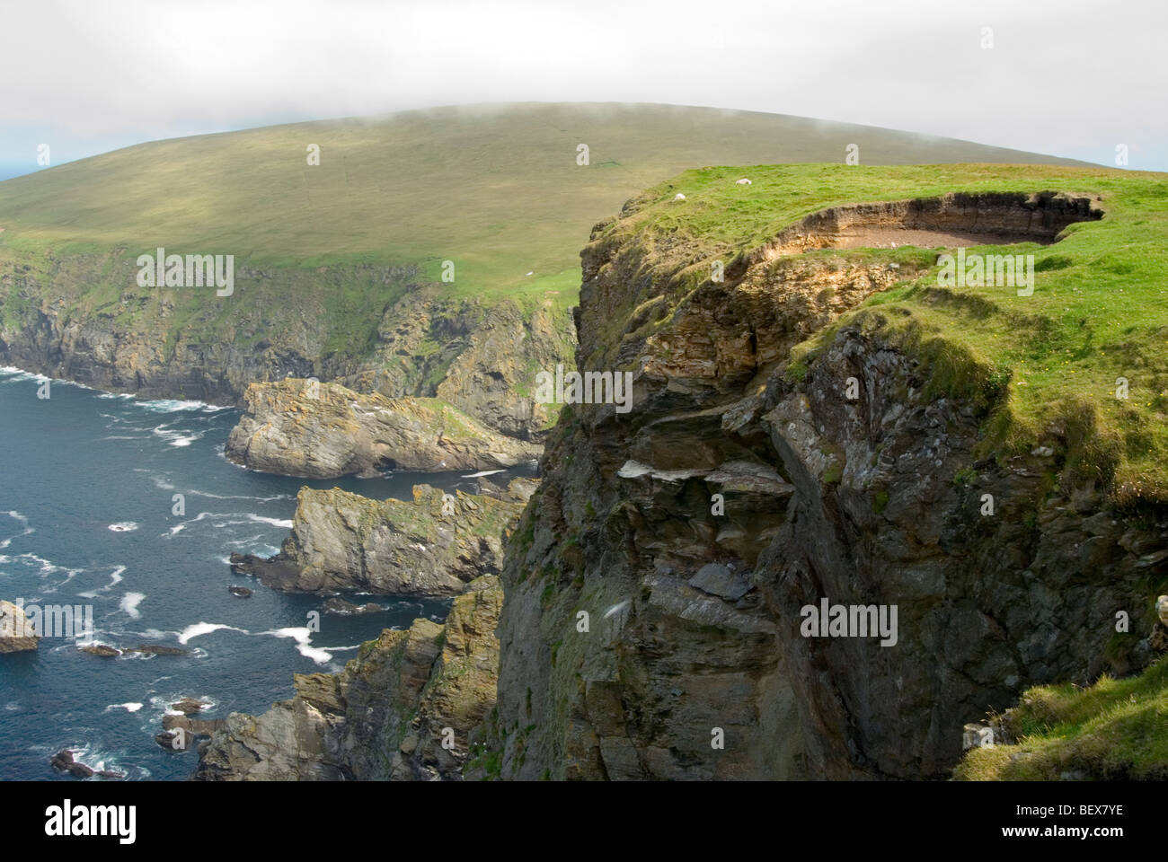 Cliffs in Hermaness National Nature Reserve surrounded by crystal blue ...