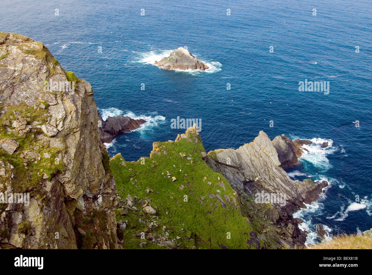 Cliffs in Hermaness National Nature Reserve surrounded by crystal blue ...
