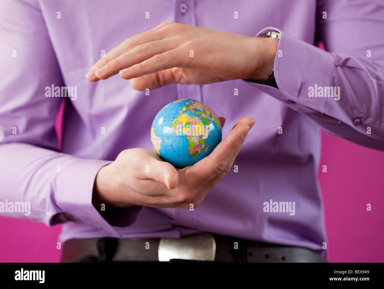 Young man holding a little globe Stock Photo - Alamy