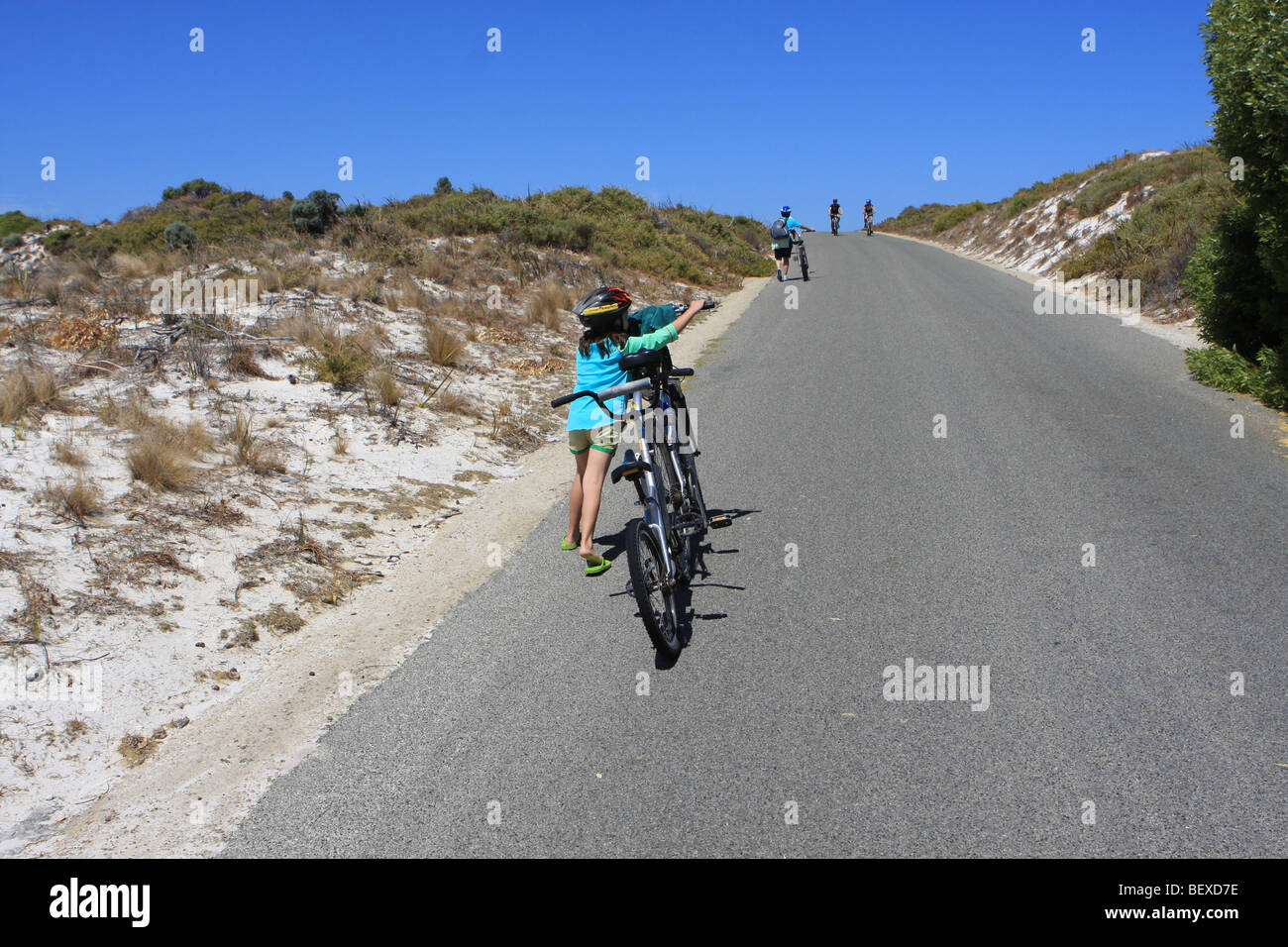 Girl pushing bicycle Stock Photo - Alamy