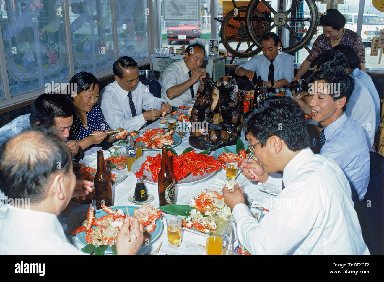Mixed Asians eating seafood at restaurant table in Japan Stock Photo ...
