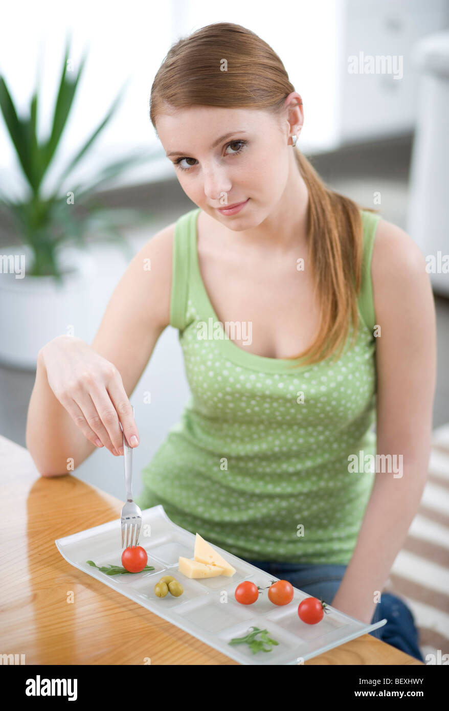 Young woman eating tomatoes Stock Photo - Alamy