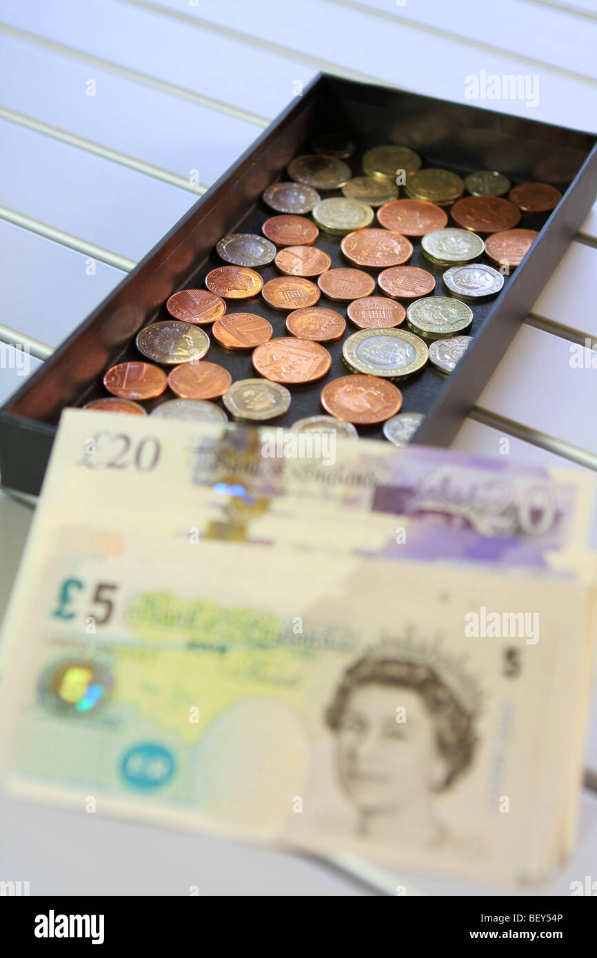 sterling notes and a box of coins on a table Stock Photo - Alamy