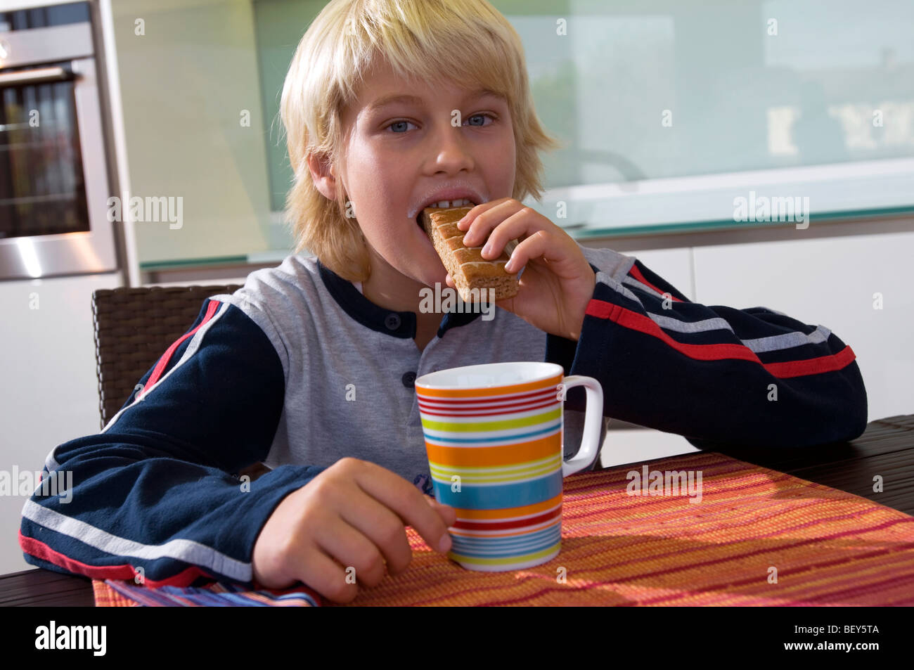 boy in kitchen eating breakfast Stock Photo - Alamy
