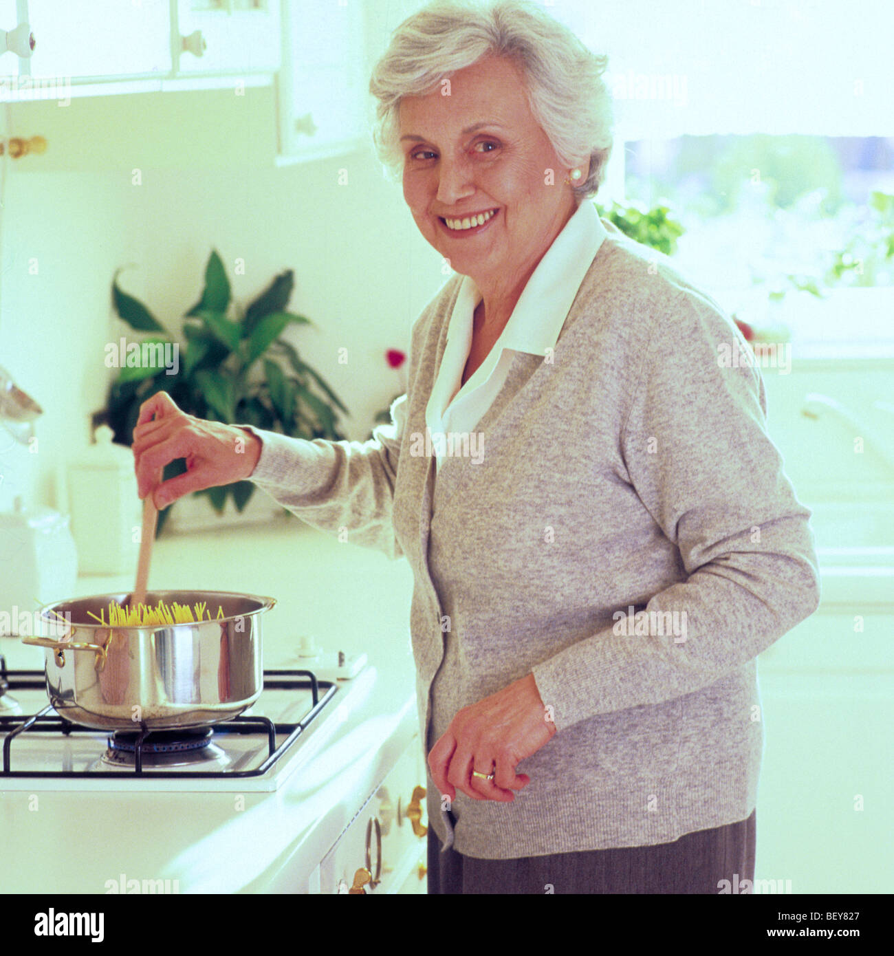 elderly woman cooking spaghetti Stock Photo - Alamy