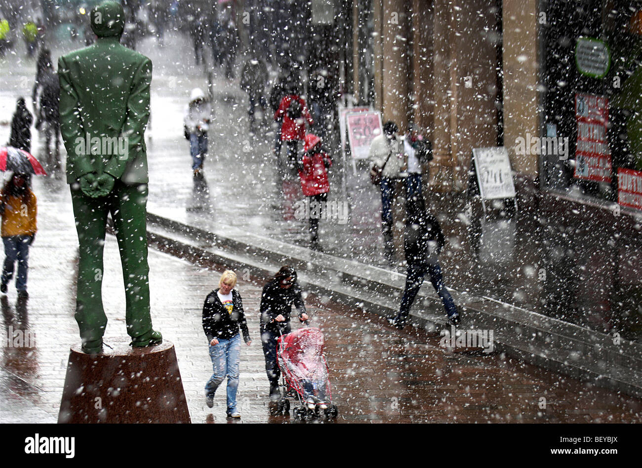 People walk through snow in the center of Glasgow, Scotland. The statue ...