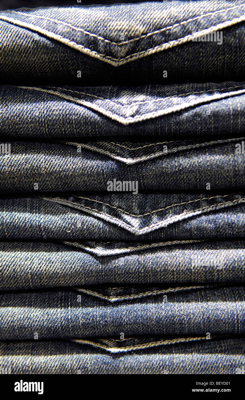 A pile of folded jeans on the shelf of a menswear store Stock Photo - Alamy