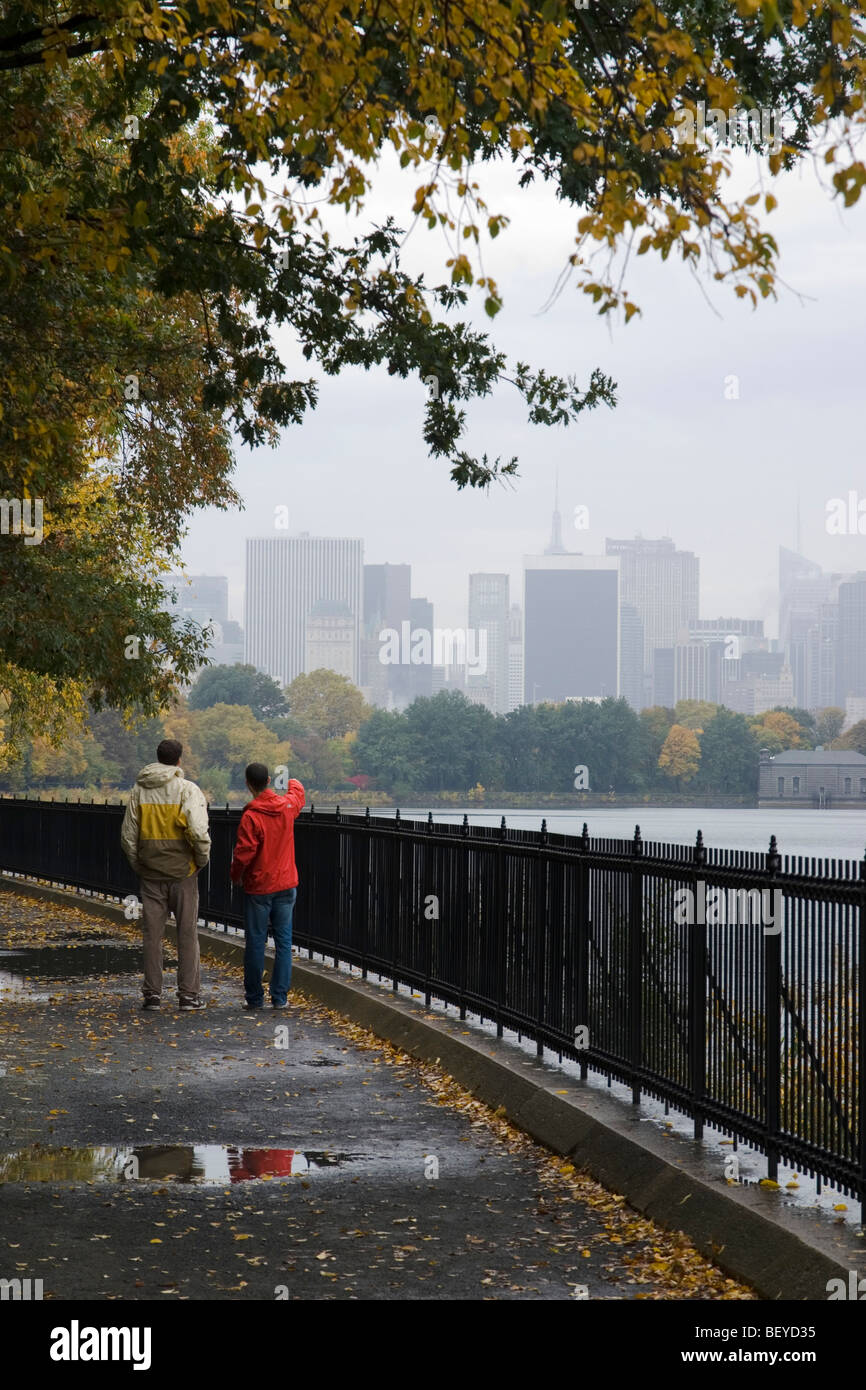 Two people walking in Central Park along the Jacqueline Kennedy Onassis ...