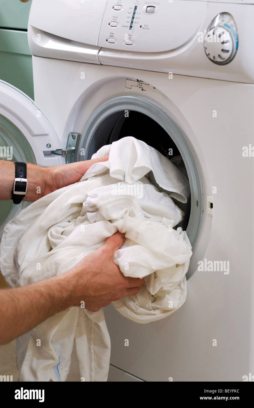 A man loading a washing machine Stock Photo - Alamy