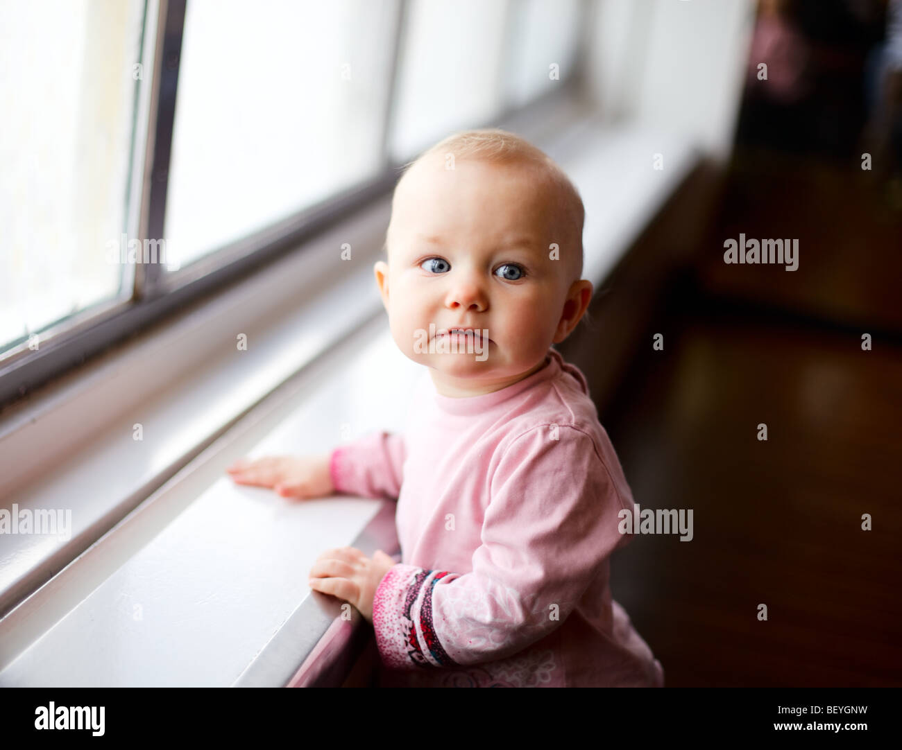 Baby girl next to the window Stock Photo - Alamy