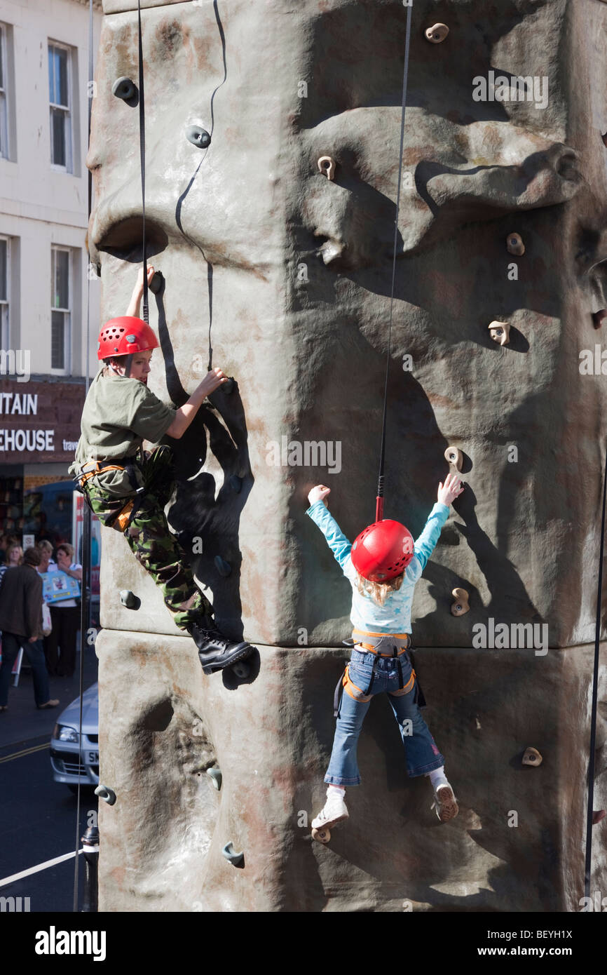 Children learning to rock climb on outdoor artificial climbing wall in ...
