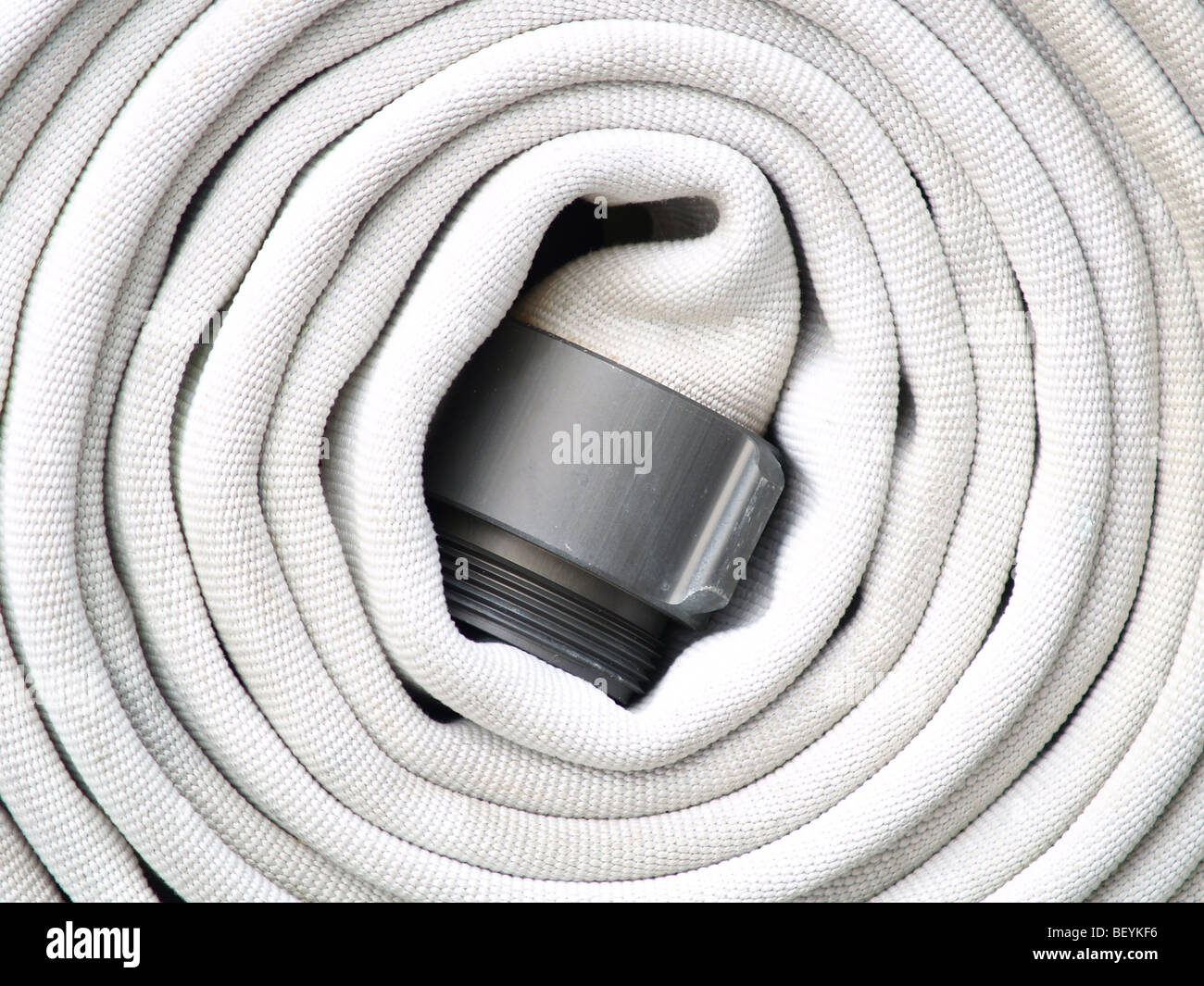 A white fire hose coiled and ready to go in case of an emergency Stock ...