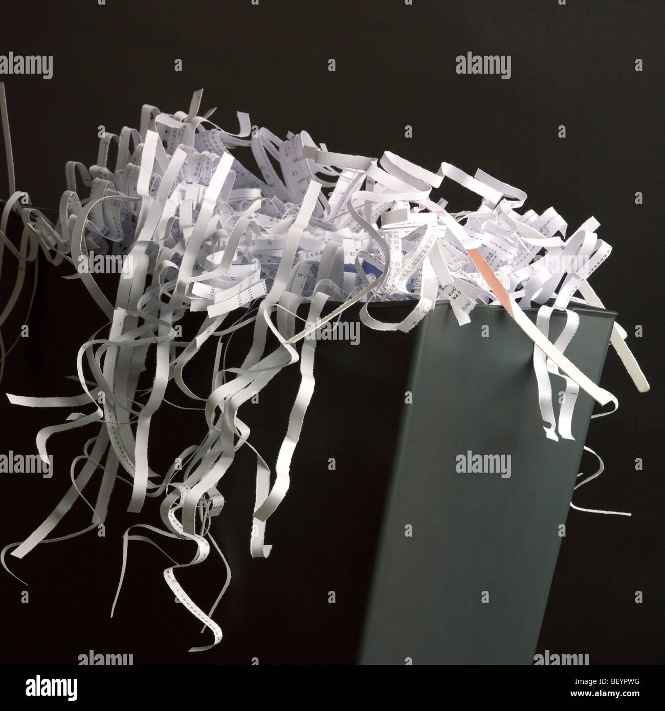 Shredded paper spilling out of a document shredder in a cluttered ...