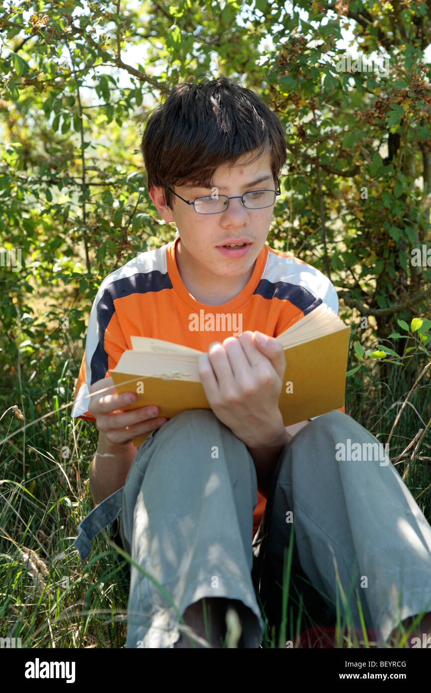 portrait of a teenage boy reading a book Stock Photo - Alamy