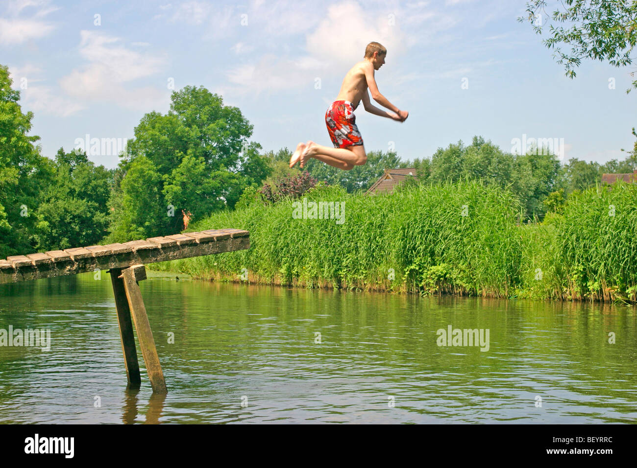 teenage boy jumping into a river Stock Photo - Alamy