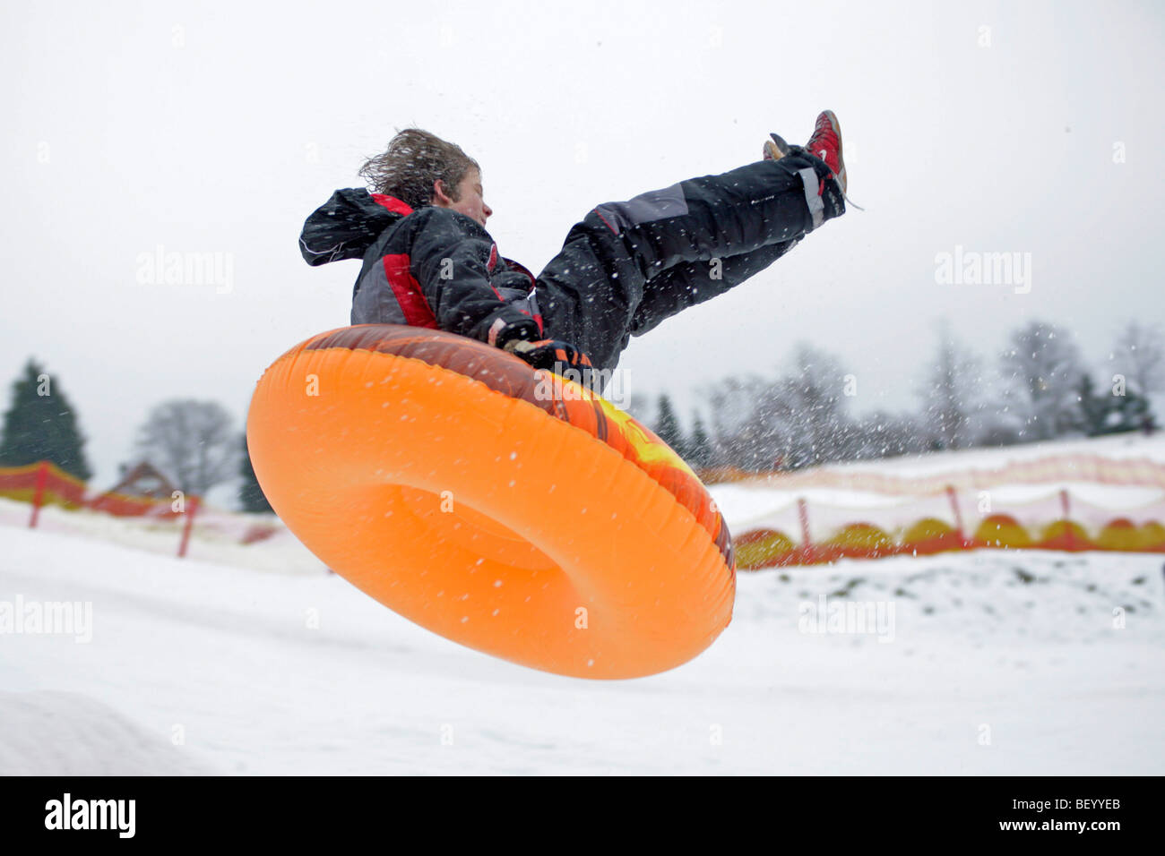 teenage boy jumping with a big rubber tire Stock Photo - Alamy