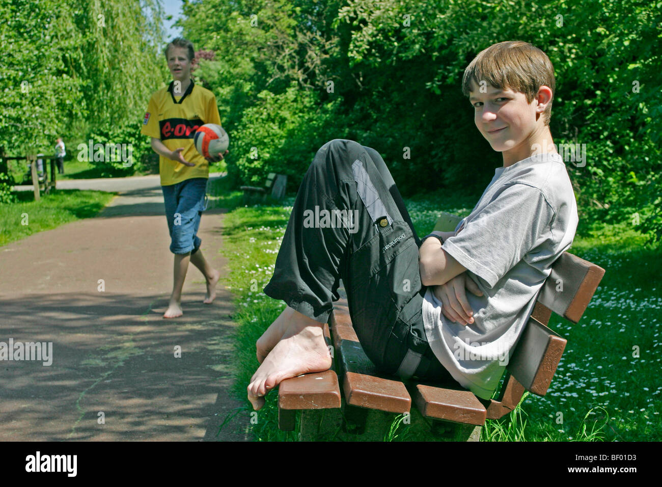 portrait of a teenage boy sitting on a bench in a park Stock Photo - Alamy
