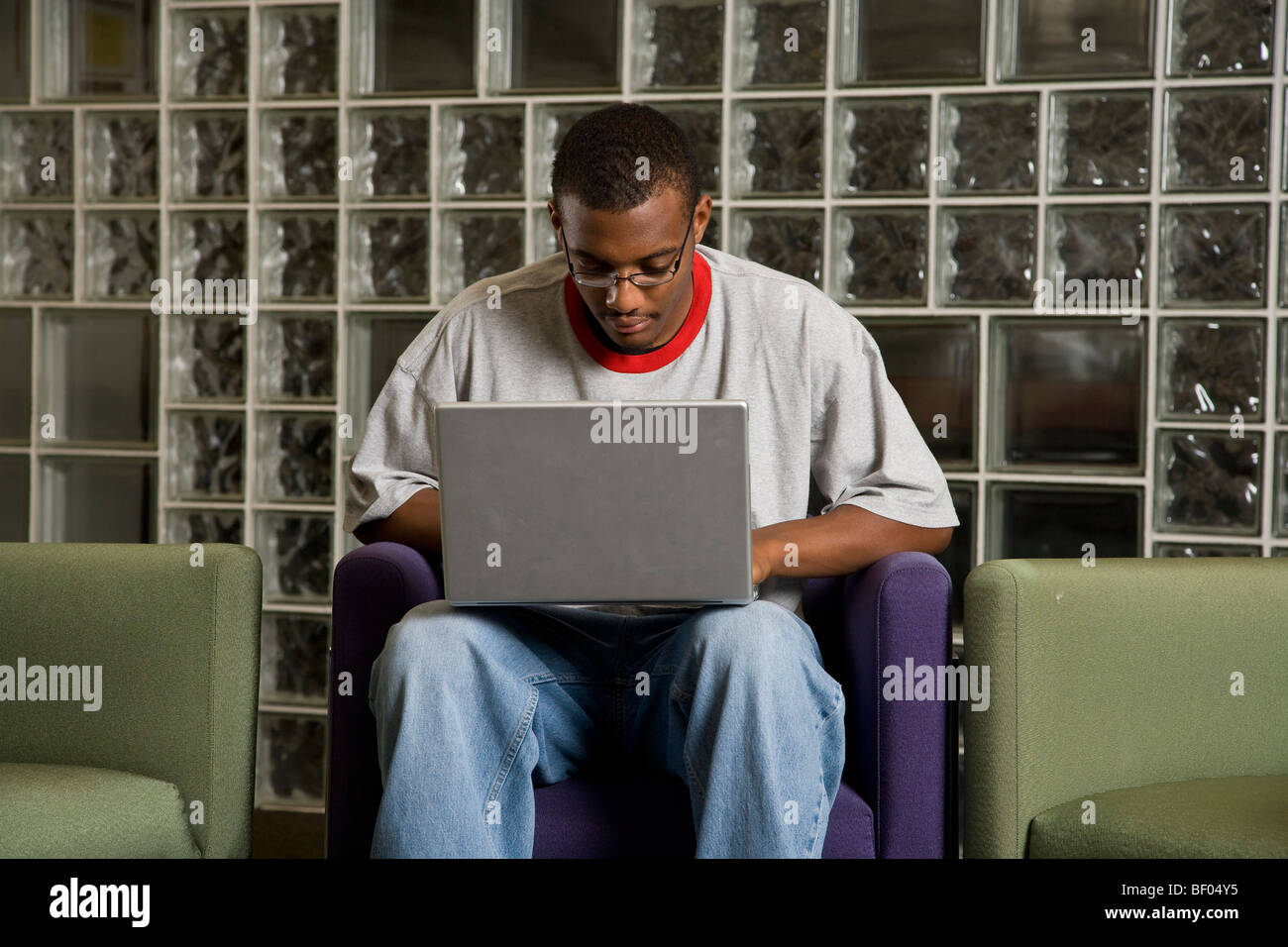 Young man uses a laptop in the library Stock Photo - Alamy