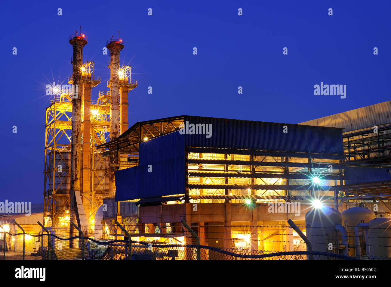 Industrial complex at night on a blue sky background Stock Photo - Alamy