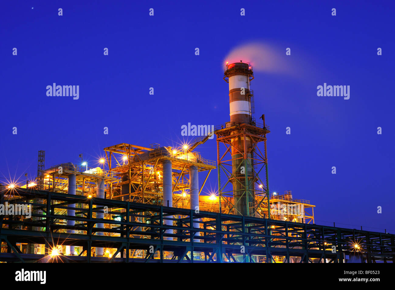 Industrial complex at night on a blue sky background Stock Photo - Alamy