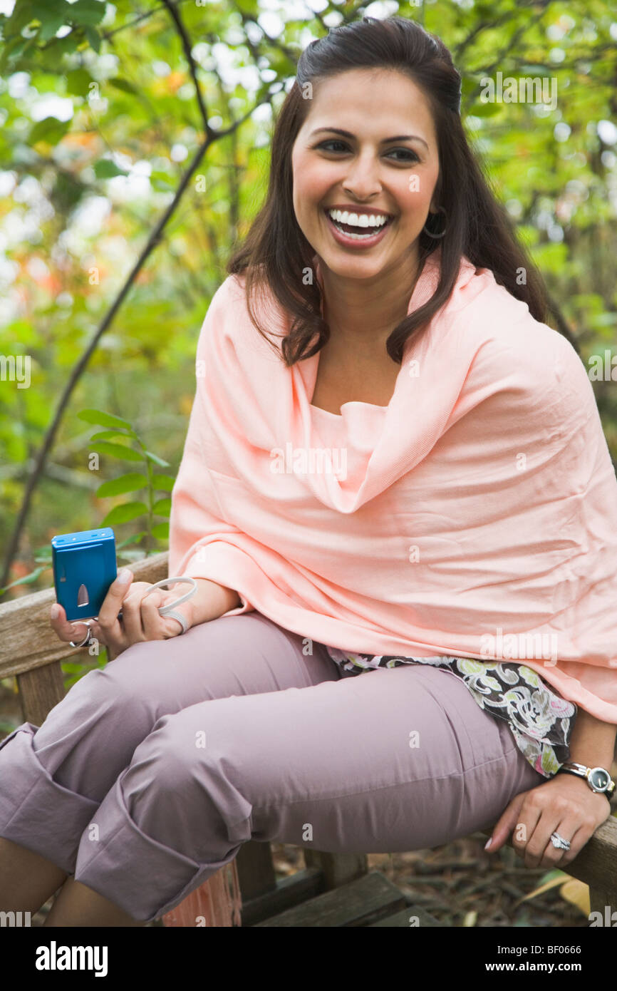 Happy woman sitting on a bench and smiling Stock Photo - Alamy