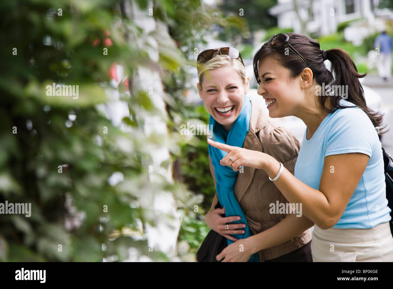 Two women standing outside store and smiling Stock Photo - Alamy