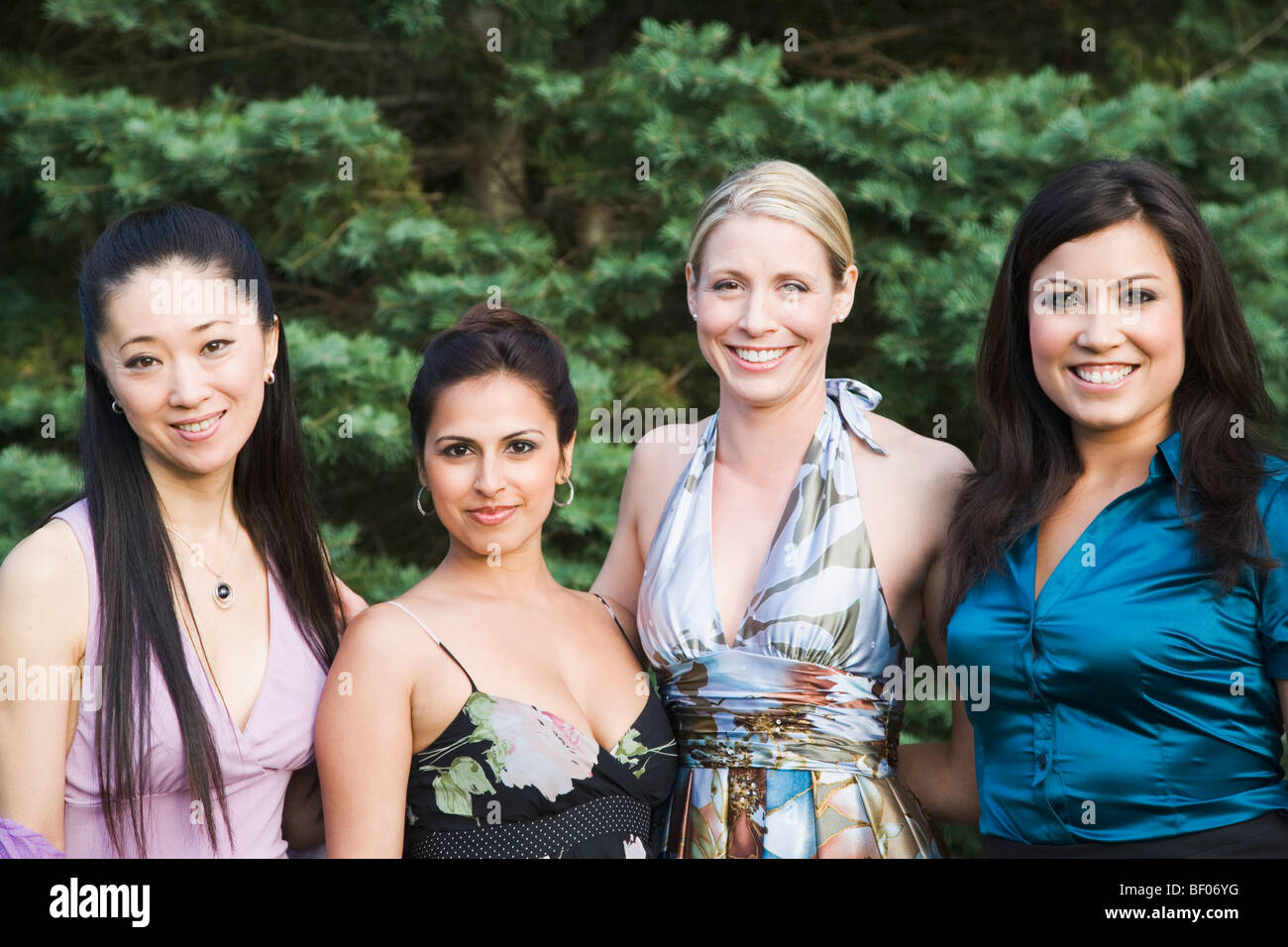 Four women standing in garden and smiling Stock Photo - Alamy