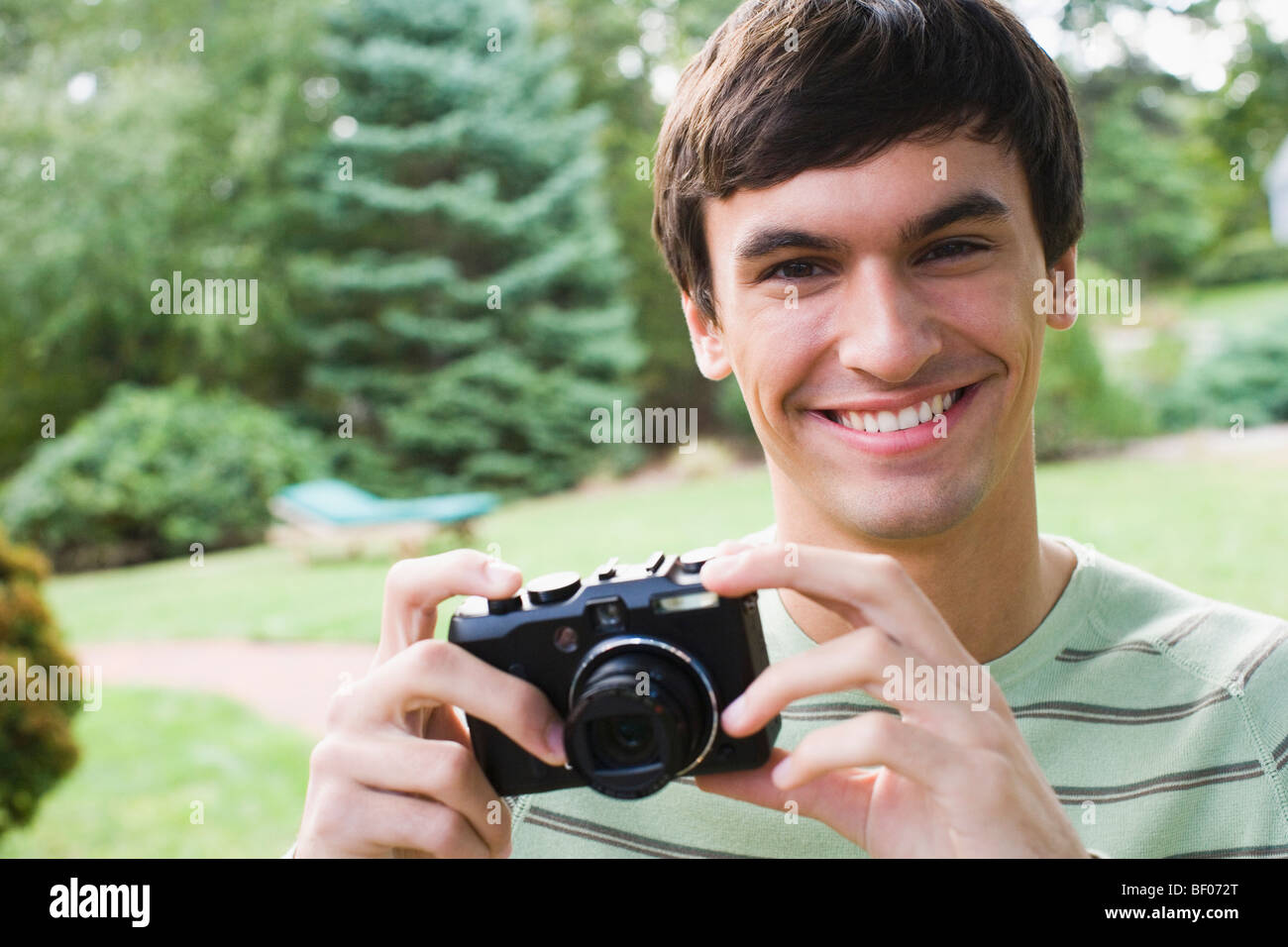 Man holding a camera and smiling Stock Photo - Alamy