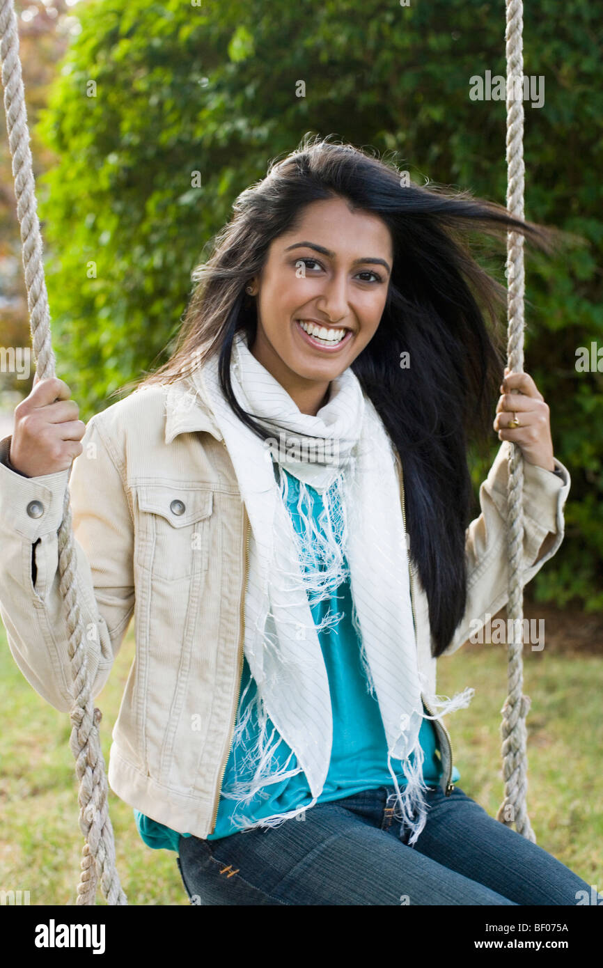 Woman swinging on rope swing and smiling Stock Photo - Alamy