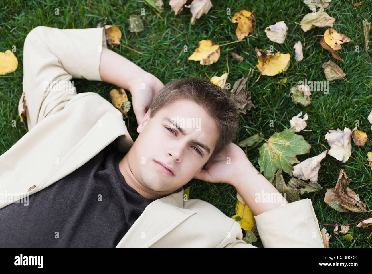 Portrait of man lying in park Stock Photo - Alamy