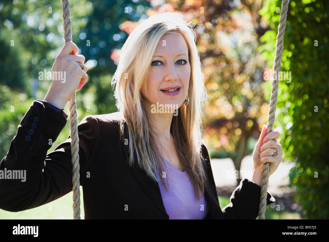 Woman sitting on a rope swing Stock Photo - Alamy