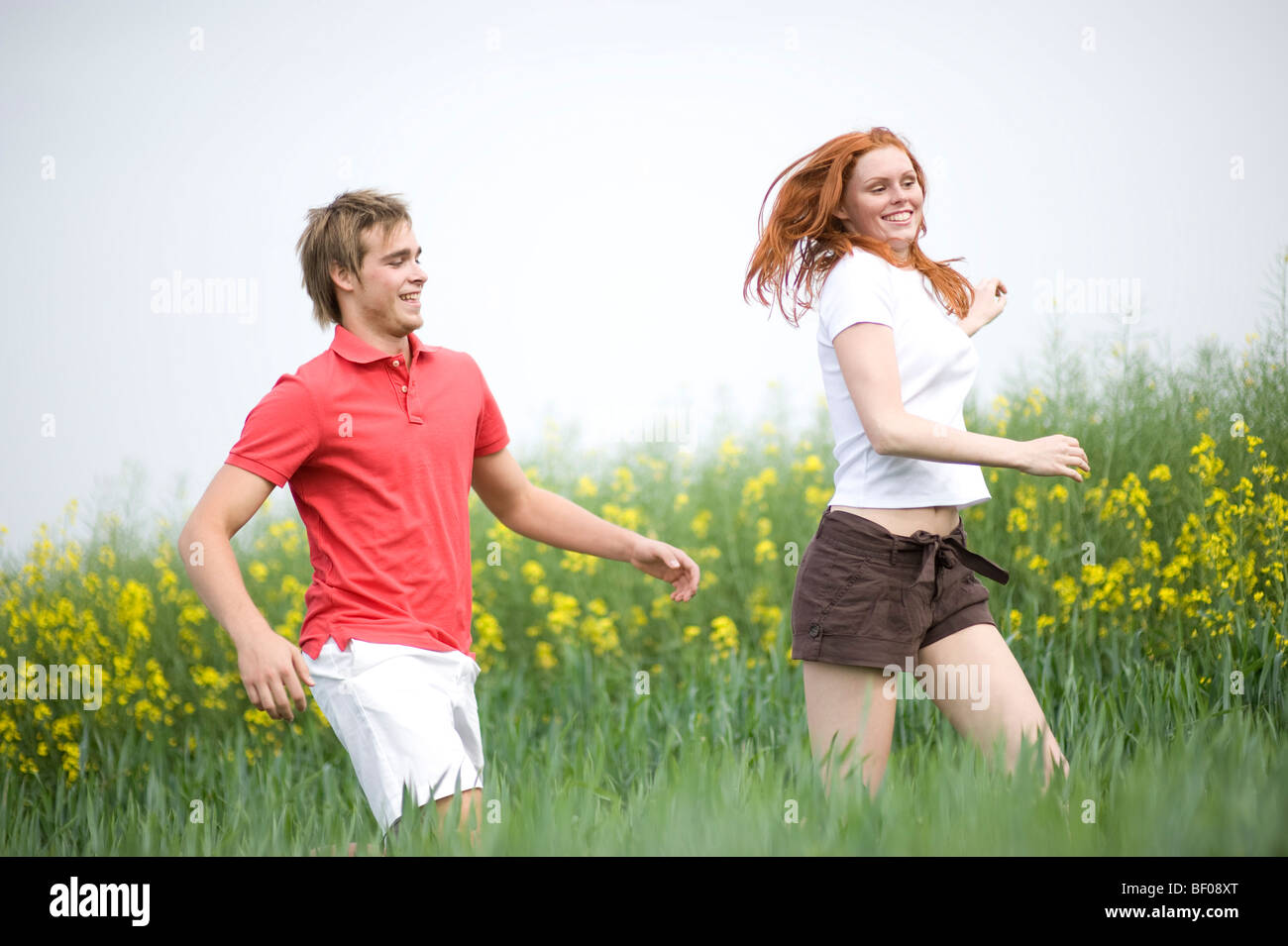 Young Couple Running in the Field Stock Photo - Alamy