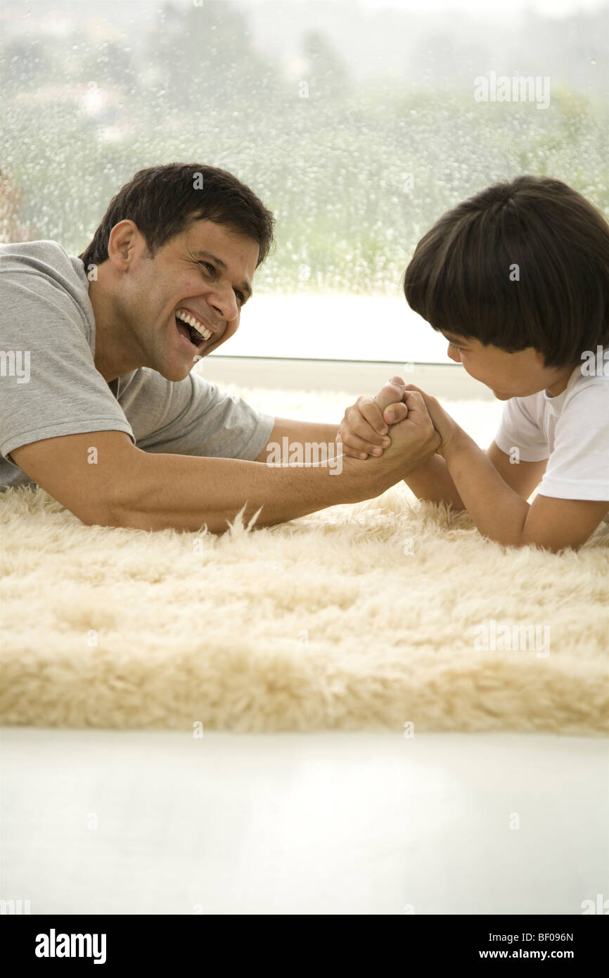 Side profile of a mature man arm wrestling with his son Stock Photo - Alamy