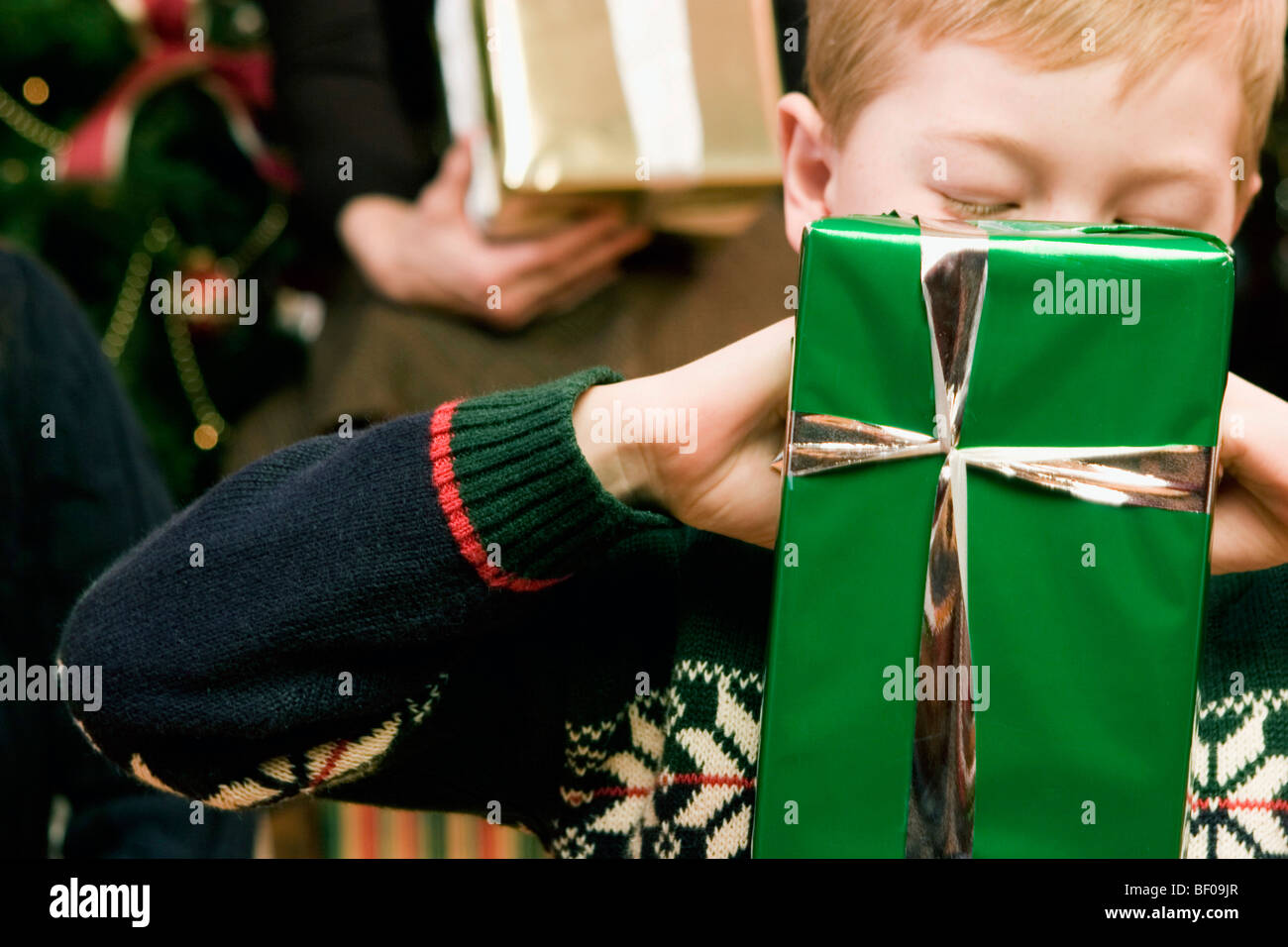 Close-up of a boy opening a Christmas present Stock Photo - Alamy