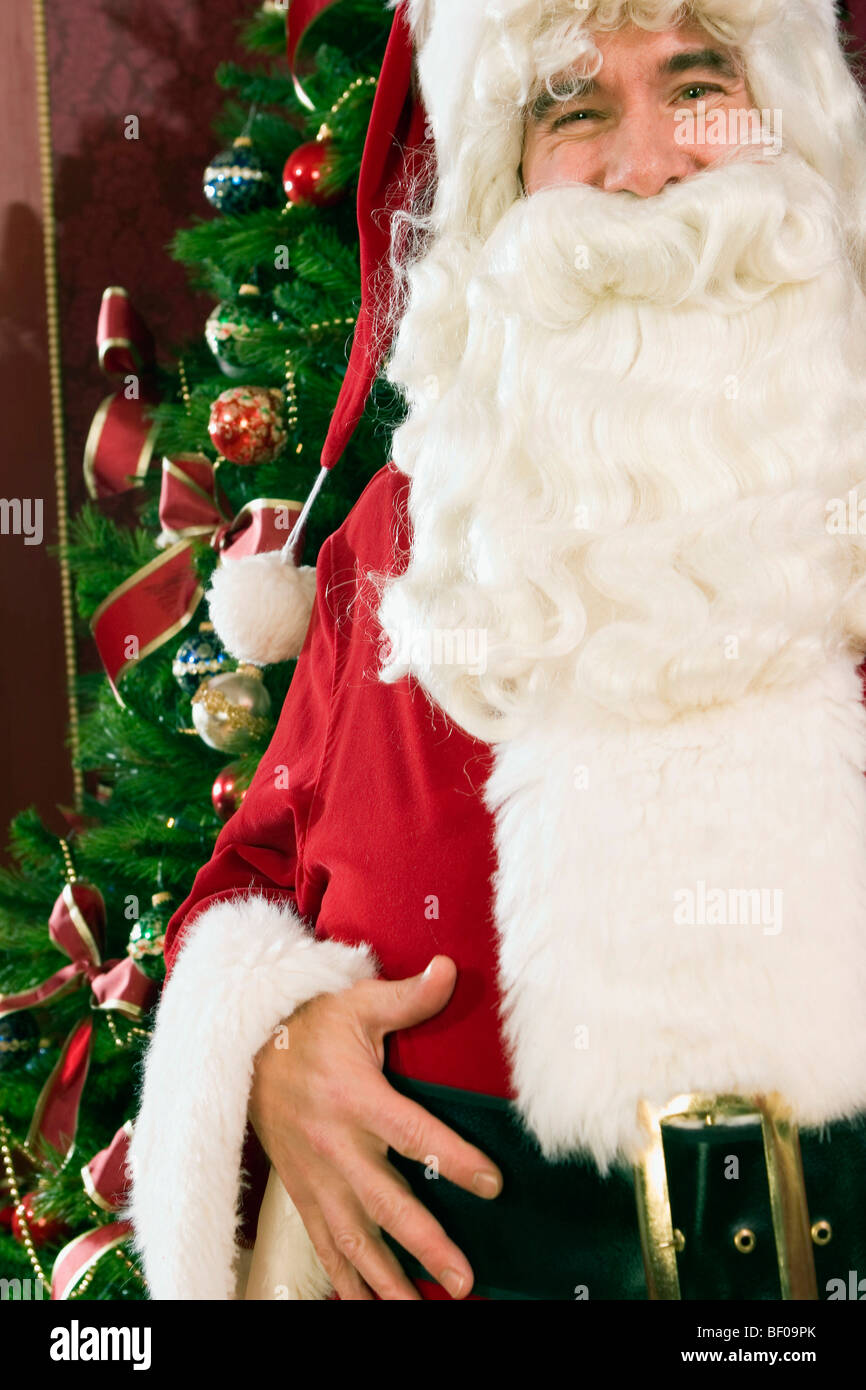Santa Claus in front of a Christmas tree Stock Photo - Alamy